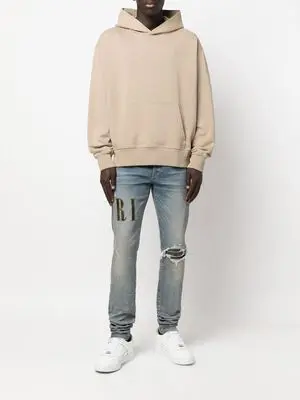 Amiri Logo-print Distressed Skinny Jeans - Blue