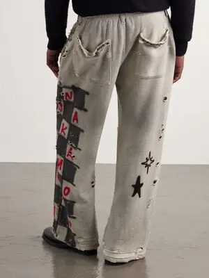 SATOSHI NAKAMOTO Get What I Want Printed Embellished Distressed Cotton-jersey Sweatpants