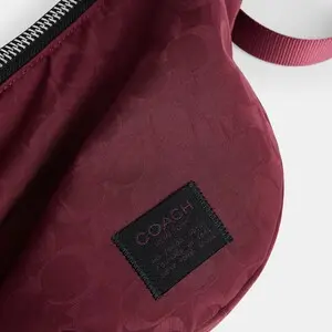 COACH Leon Sling Bag In Signature Nylon Jacquard - Light Maroon