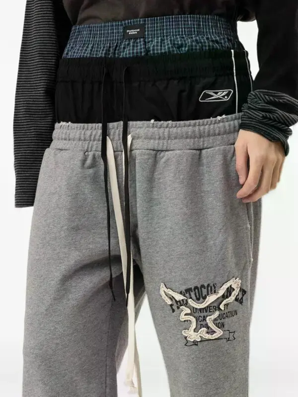 PROTOCOL INDEX Layered Eagle-patch Track Pants