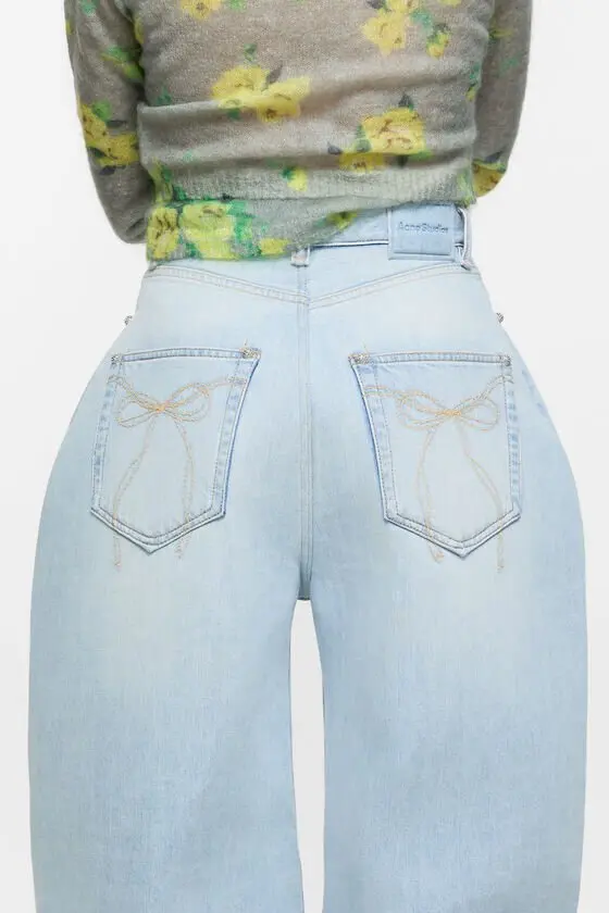 Acne Studios Light Wash Denim Trousers With Embroidered Bows