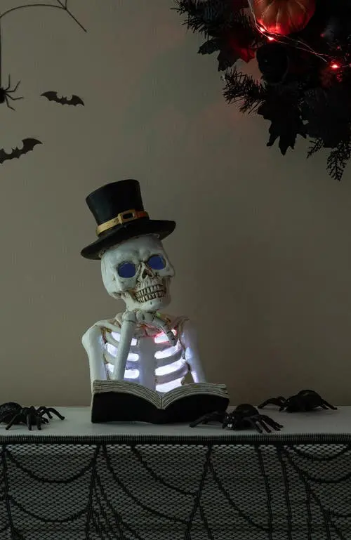 GLITZHOME 10.25"h Halloween Lighted Resin Skull Reading Book Table Decor