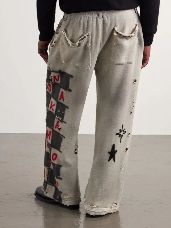 SATOSHI NAKAMOTO Get What I Want Printed Embellished Distressed Cotton-jersey Sweatpants