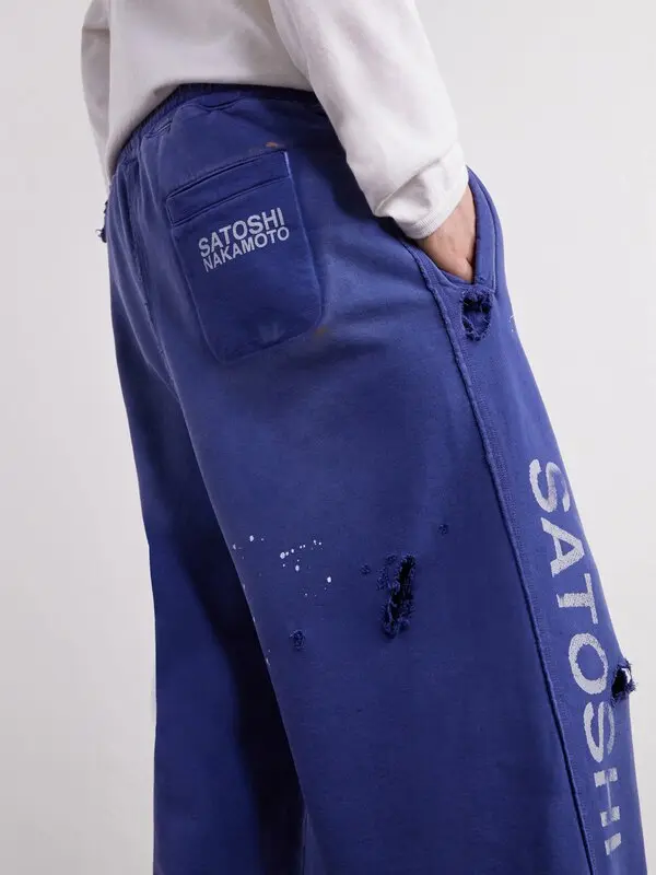 SATOSHI NAKAMOTO Luke Logo-printed Paint-splattered Distressed Cotton-jersey Drawstring Sweatpants