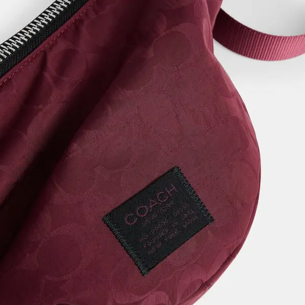 COACH Leon Sling Bag In Signature Nylon Jacquard - Light Maroon