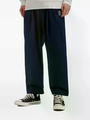 FINGERCROXX Pleated Logo-patch Trousers