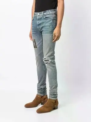 Amiri Logo-embroidered Ripped-detail Jeans - Blue