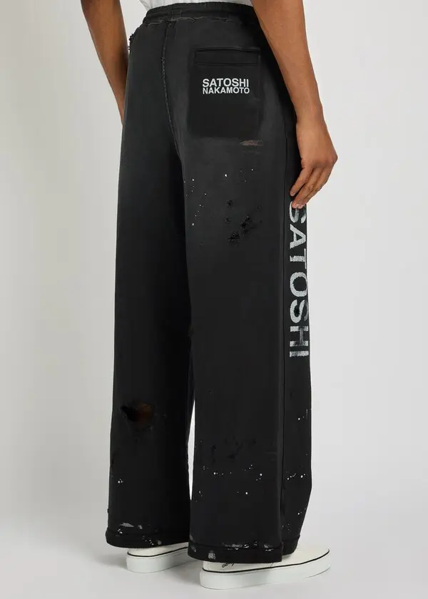 SATOSHI NAKAMOTO Luke Printed Distressed Wide-leg Cotton Sweatpants - Black