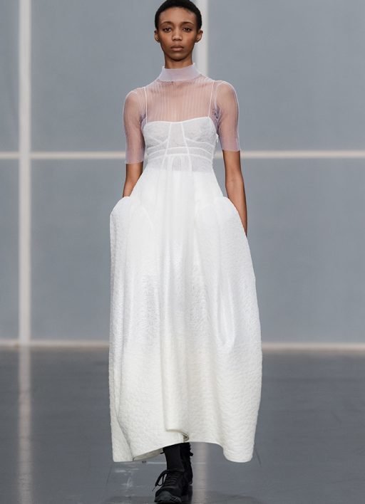 Cecilie Bahnsen FW20 showcases a unique white midi dress with sheer puff sleeves and a textured skirt, adding modern elegance to the collection