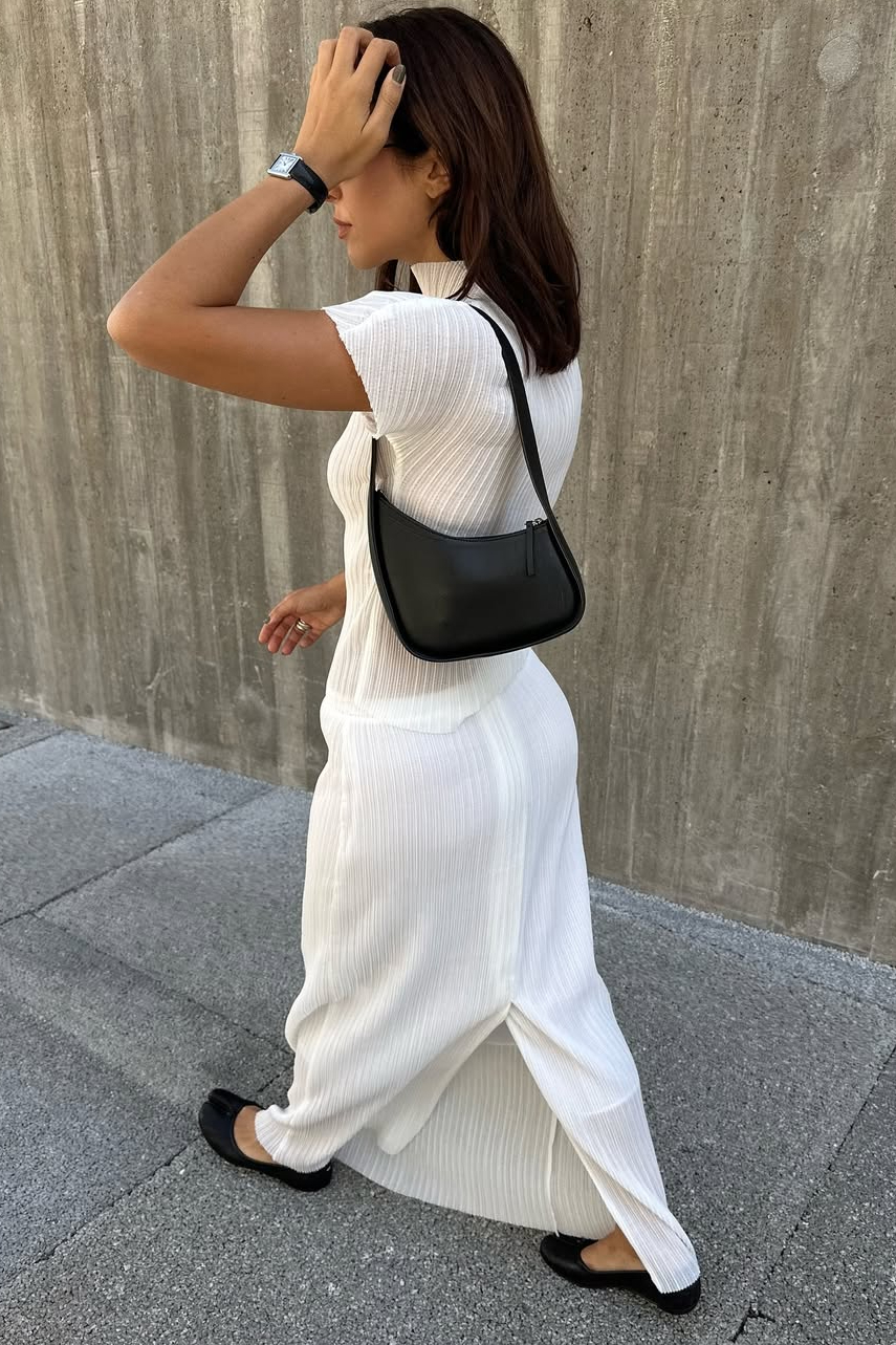 Effortlessly chic outfit featuring a ribbed white matching skirt set paired with a black shoulder bag and ballet flats%2C perfect for summer styling