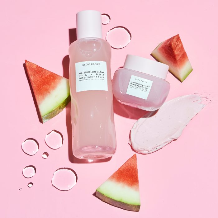 A set of skincare products placed on a pink background.