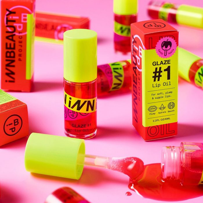 A set of Lip Glow Oil bottles kept on a pink surface.