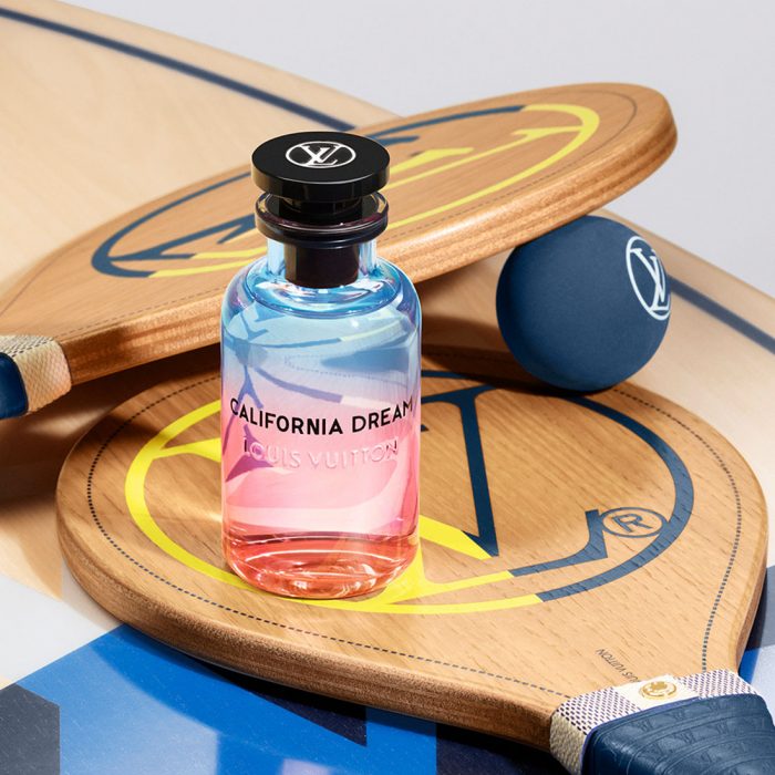 A Louis Vuitton perfume bottle is placed atop a bat.