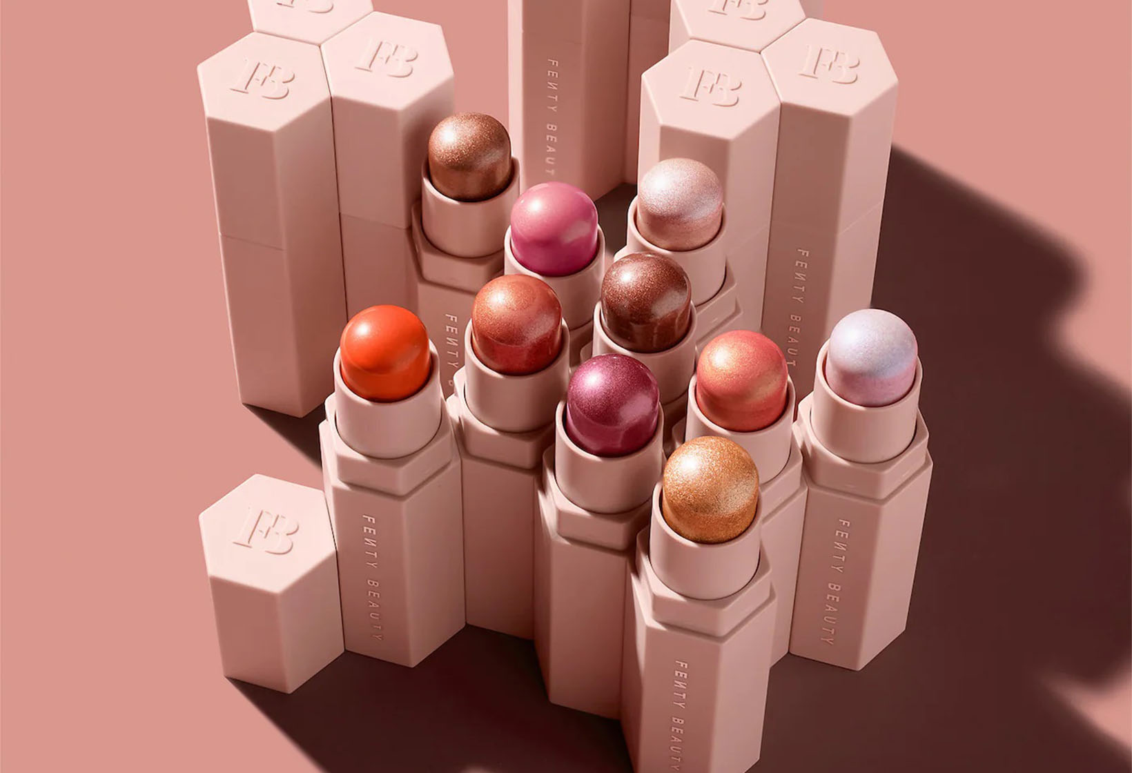 A set of blush sticks placed on a peach background.