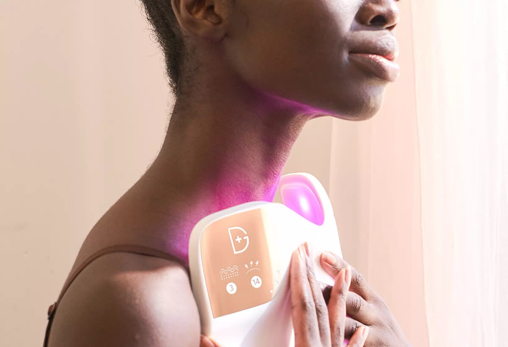 Close-up of LED light therapy device on neck and chest%2C showcasing at-home skincare treatment for firming and anti-aging benefits