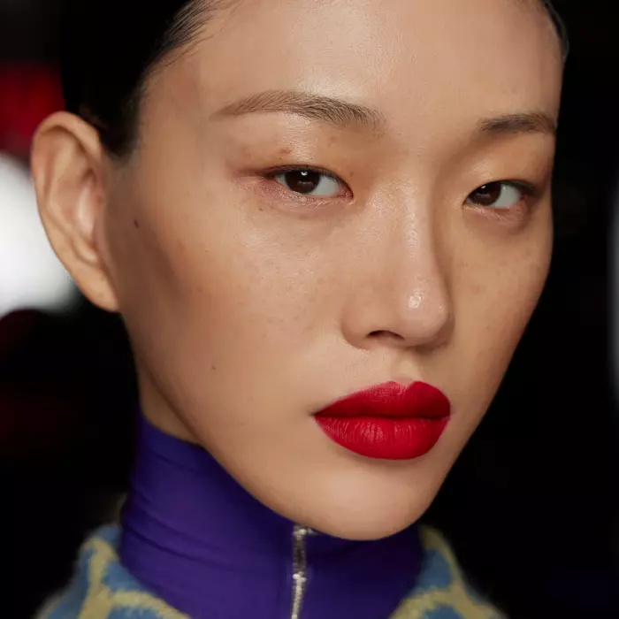 A closeup of a woman's face wearing bright red lipstick.
