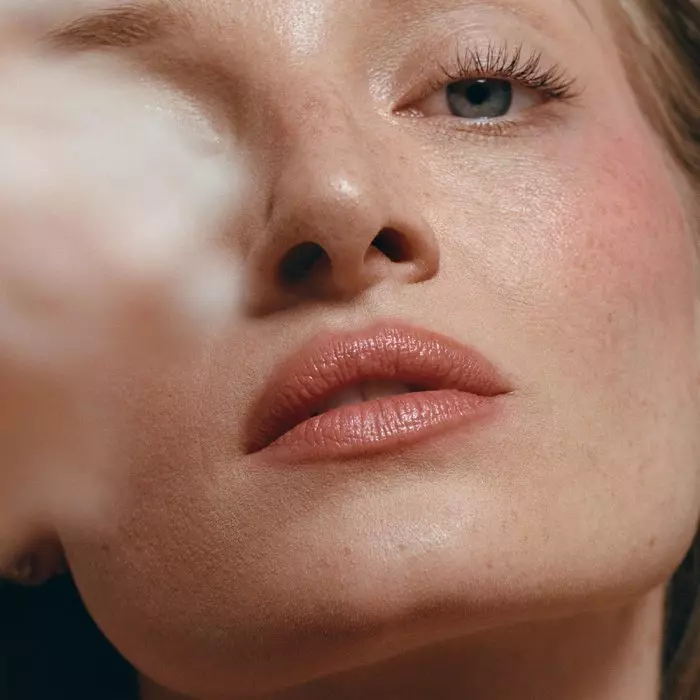 A woman's face after applying the blush. 