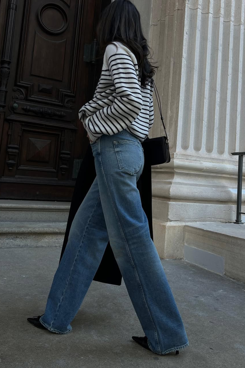 Casual chic outfit featuring a black and white striped sweater%2C high-waisted light wash jeans%2C and sleek black pointed-toe flats%2C styled for a modern aesthetic