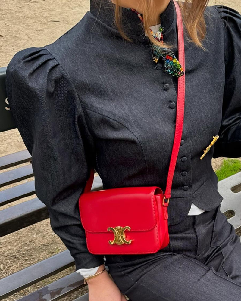 Chic dark denim outfit with puffed sleeves paired with a vibrant red Celine bag featuring gold hardware%2C styled for a modern look