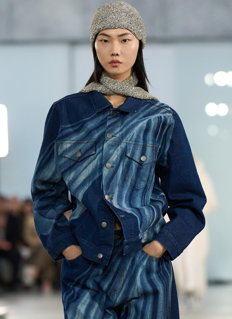 Model wearing Giuseppe Di Morabito blue wave-patterned denim jacket and matching pants with scarf