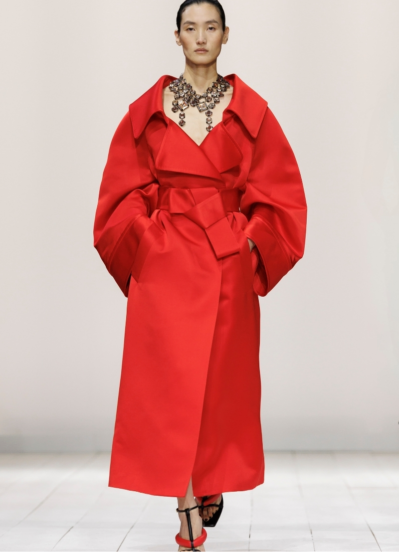 Red satin wrap coat with oversized collar and statement crystal necklace on the runway