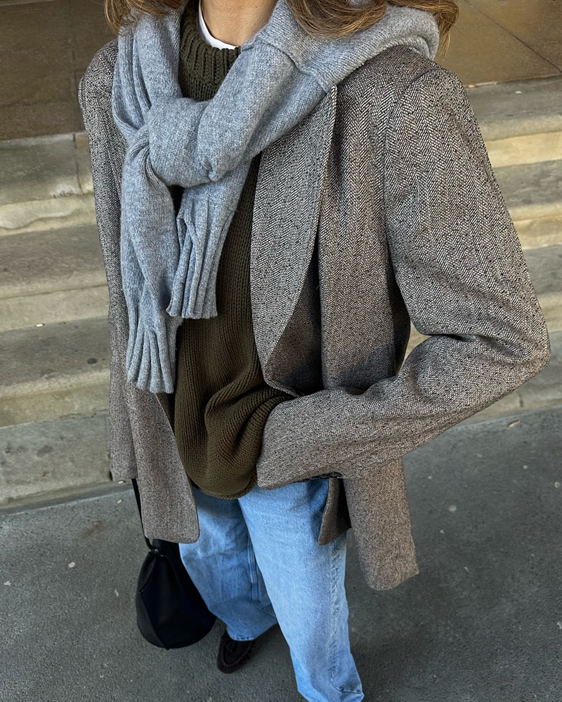 Casual street style look featuring gray tweed blazer%2C knit sweater%2C soft scarf%2C light blue jeans%2C and black leather bag on city steps