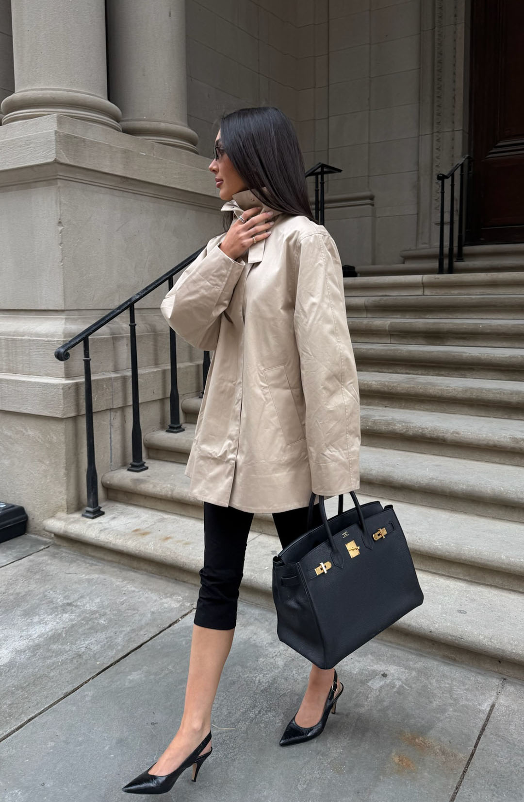Street style look with a beige trench jacket%2C black slingback heels%2C and a Herm%C3%A8s Birkin bag on stone steps