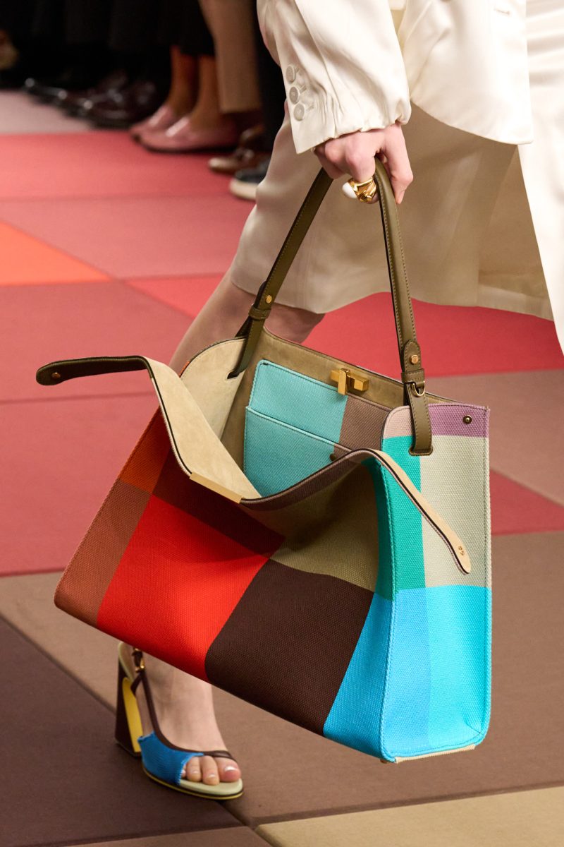 Color-block tote bag in canvas with red, brown and turquoise panels, styled with a neutral skirt suit and sandals for a modern runway look