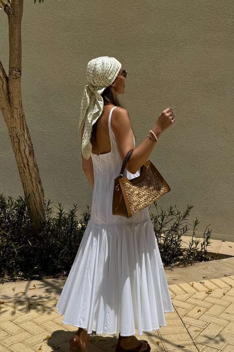 Flowy white maxi dress paired with a patterned scarf and a stylish woven handbag%2C ideal for summer outings in Carmel by the Sea