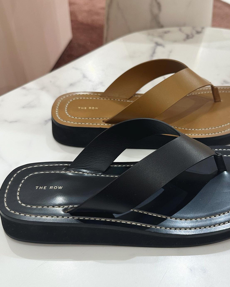 The Row leather thong sandals in black and tan with wide straps and stitched soles%2C minimalist luxury summer footwear