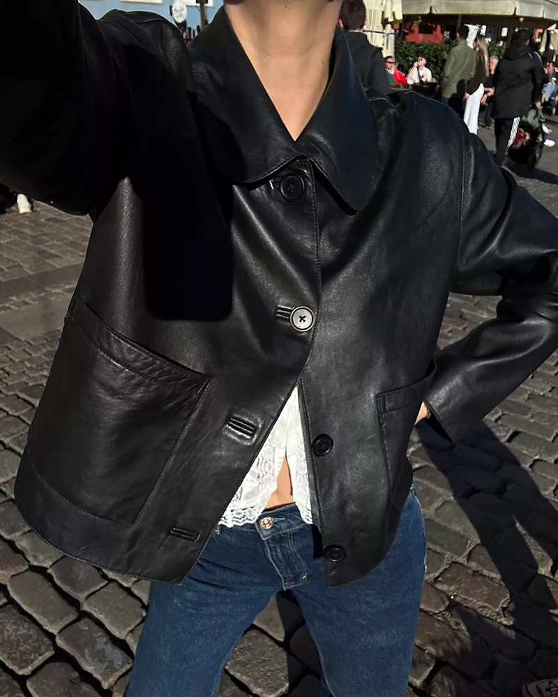 Chic Free People black leather cropped jacket layered over a delicate white lace top%2C styled with high-waisted denim jeans