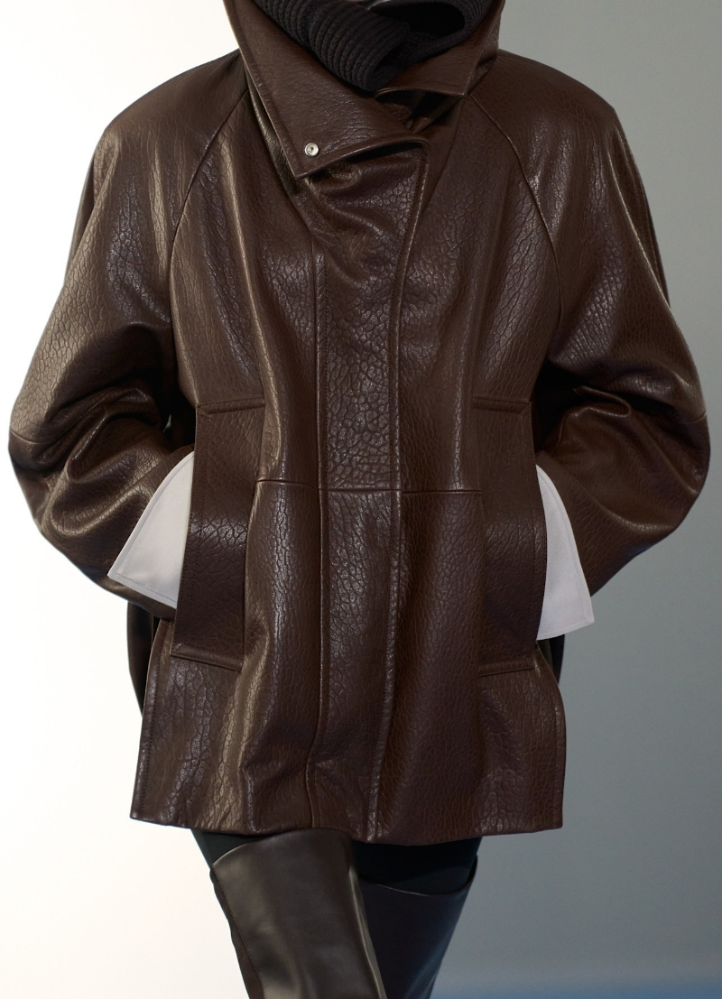 Textured chocolate brown leather jacket with high collar and sculpted waist styled on the runway