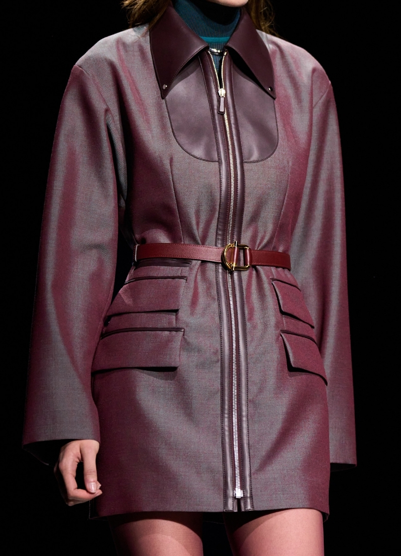 Burgundy belted mini coat with leather collar, zip front and utility pockets presented on the runway