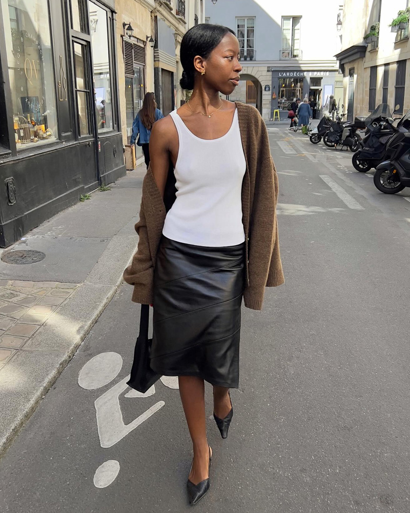Street style look with brown cardigan%2C white tank top and black leather midi skirt on a Paris street