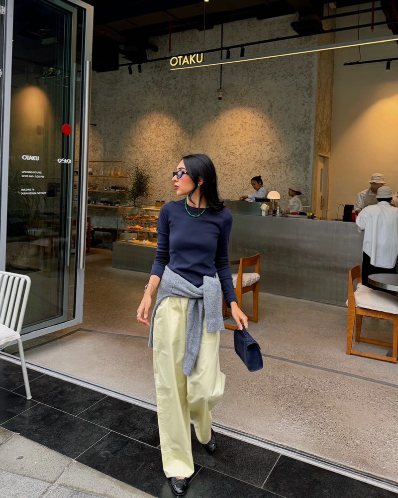 Navy long sleeve top with wide-leg trousers and sweater tied at waist%2C styled with flats for effortless weekend outfit