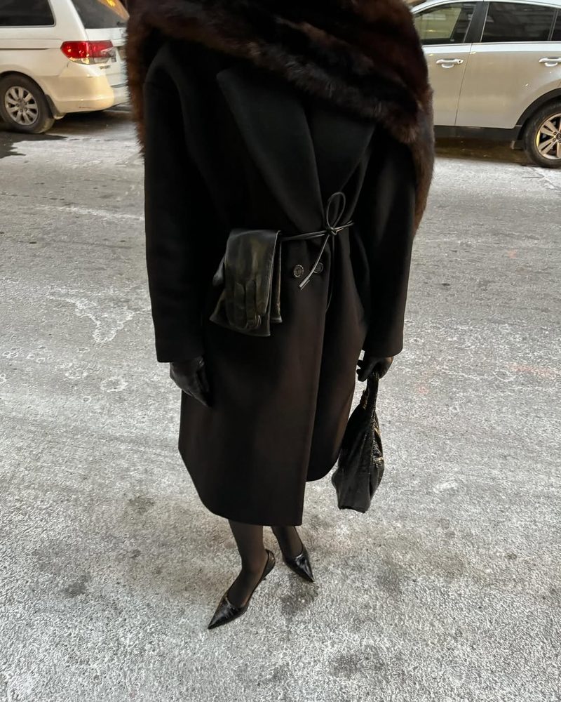 Sleek black wool coat with a luxurious fur collar%2C paired with pointed-toe heels%2C styled with a chic leather bag for a polished winter look.