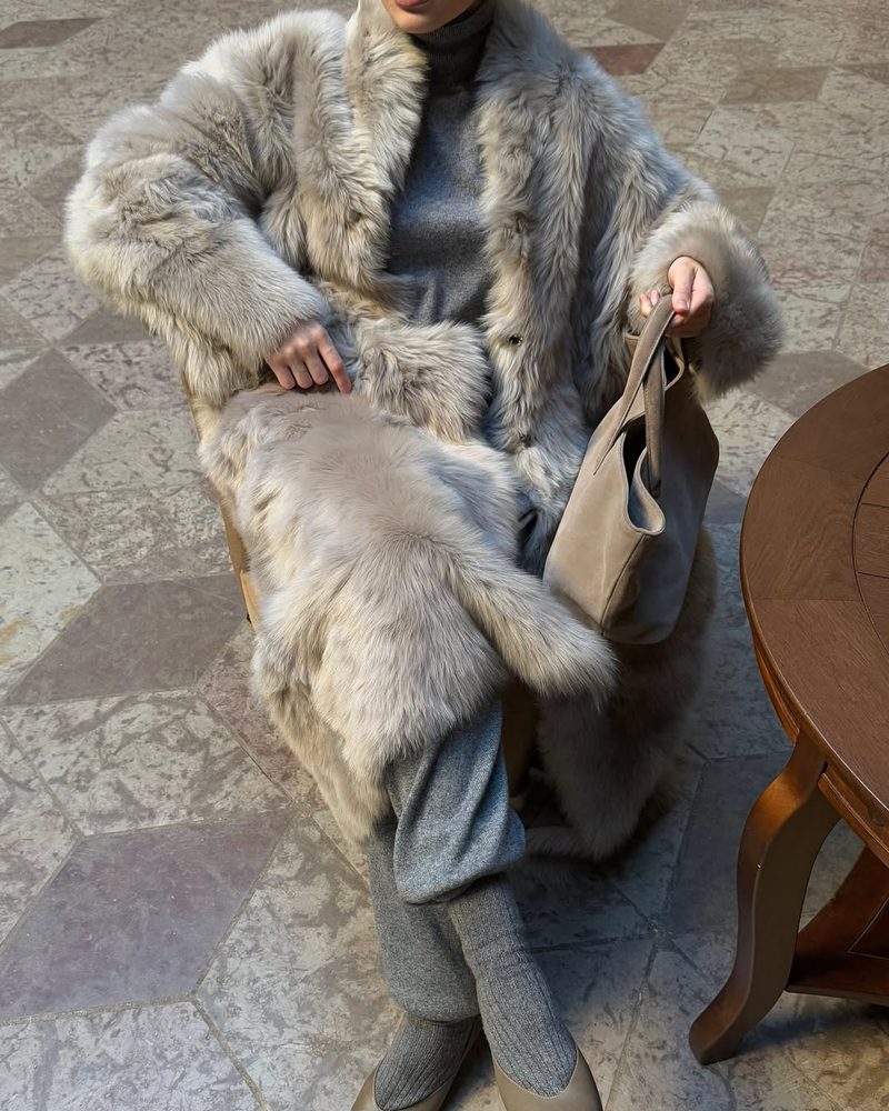 Luxurious faux fur winter coat paired with a gray turtleneck%2C soft knit pants%2C and beige heeled mules%2C elegantly styled for casual winter outings