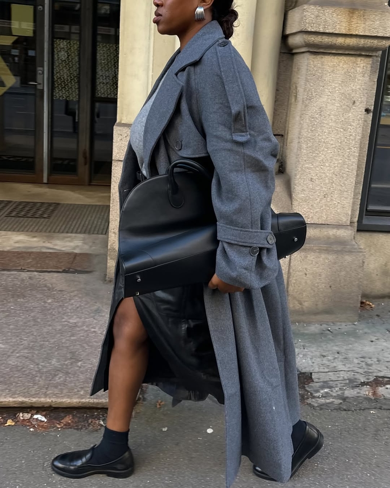 Chic gray wool coat styled with a sleek black handbag%2C paired with a fitted gray top and leather skirt for autumn street style