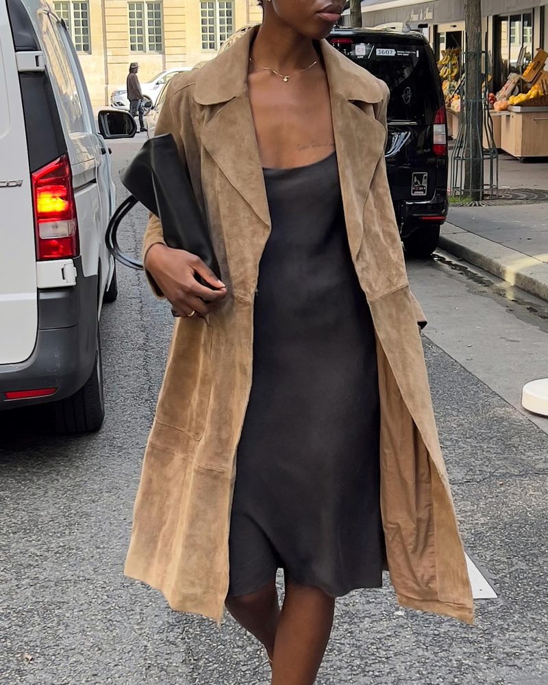 A chic winter midi dress styled with a tan suede coat and a sleek black clutch%2C exuding contemporary elegance on city streets