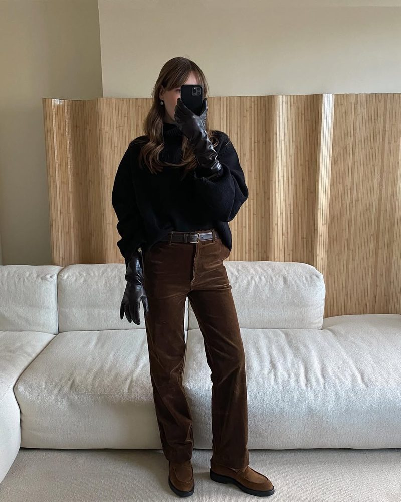 Cozy black oversized sweater paired with brown corduroy flared pants and chic leather gloves%2C styled for a modern autumn look