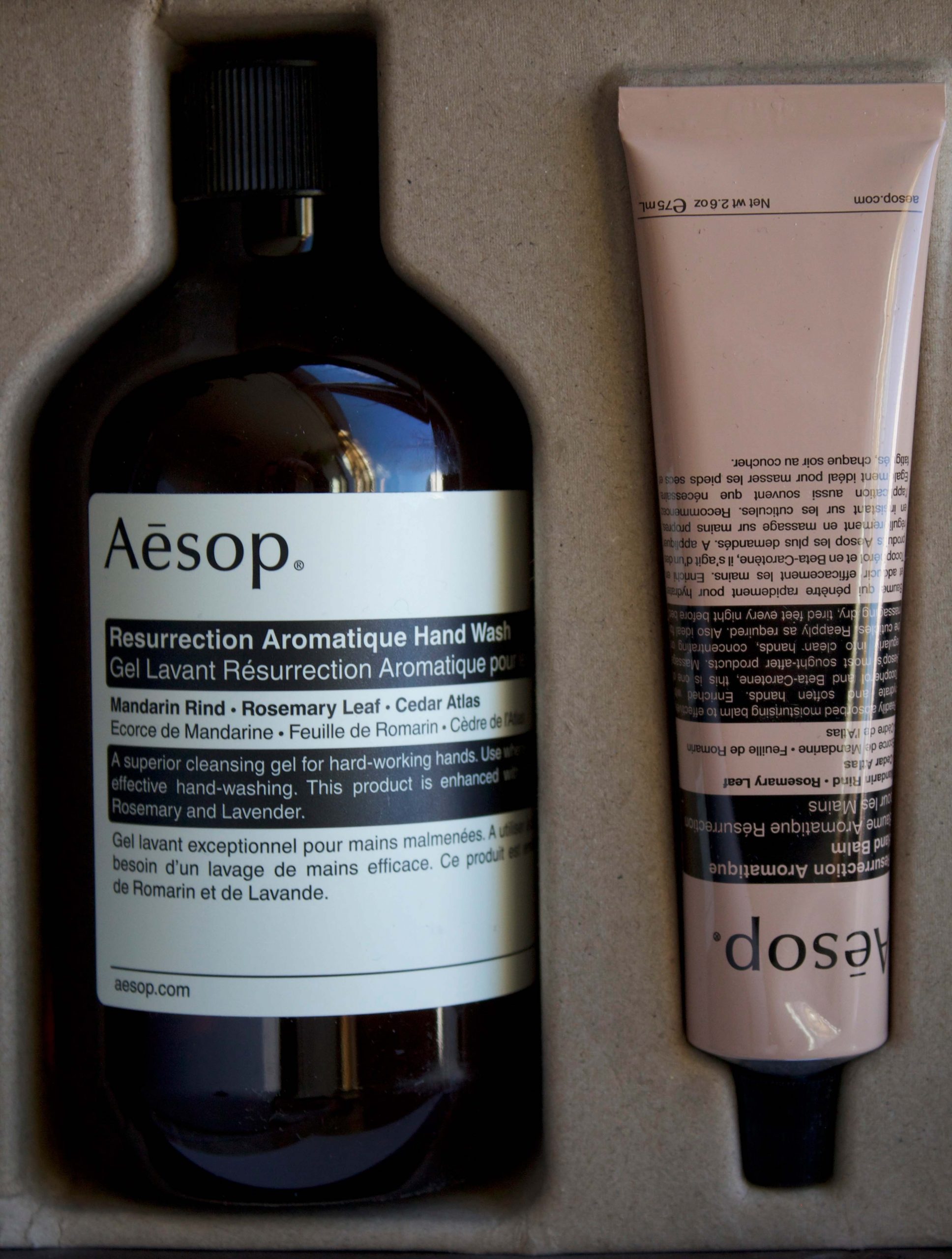 Aesop Resurrection Aromatique hand wash and hand balm set in amber bottle and pink tube on molded packaging