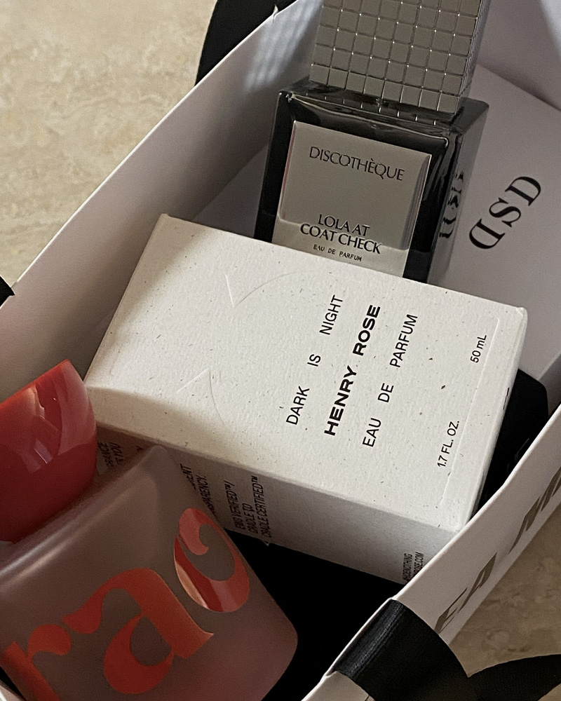 Curated perfume selection featuring Discoth%C3%A8que%2C Henry Rose%2C and a red-capped fragrance bottle arranged inside a chic black-and-white gift bag