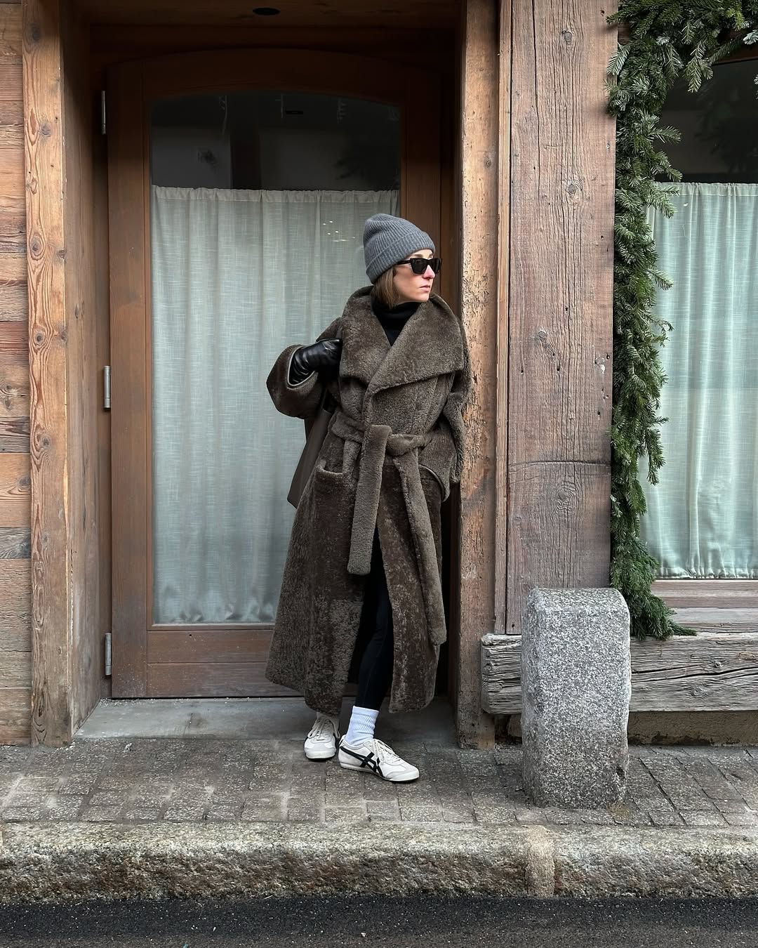 Cozy oversized brown faux fur coat paired with sleek black leggings and classic white sneakers%2C styled with a gray beanie and sunglasses
