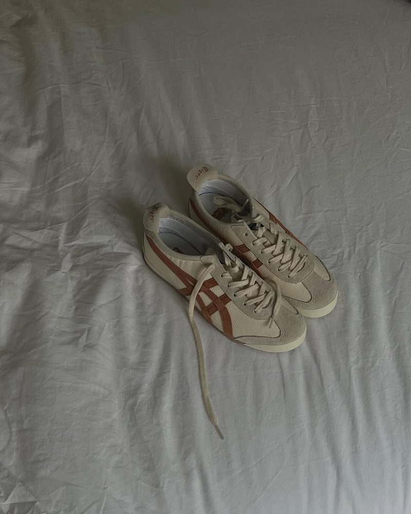 Asics sneakers featuring a beige and rust color palette with a retro design%2C set against a crisp white backdrop