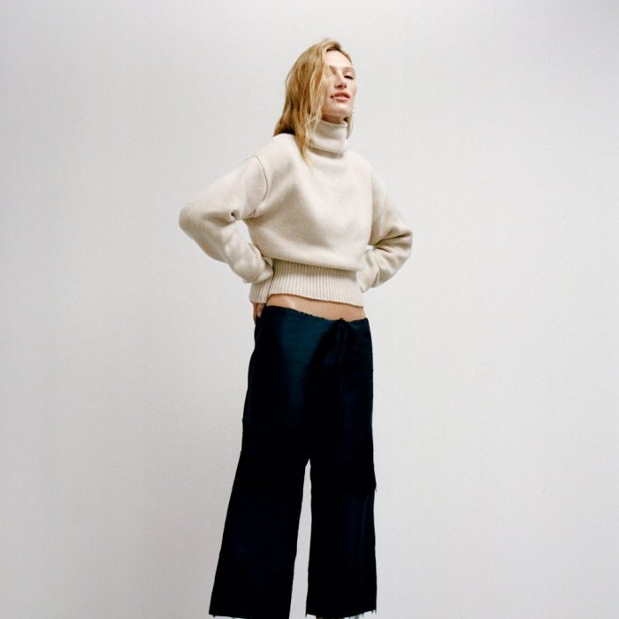 Cozy beige turtleneck sweater paired with black wide-leg cropped pants, completed with stylish black loafers for a chic autumn look.