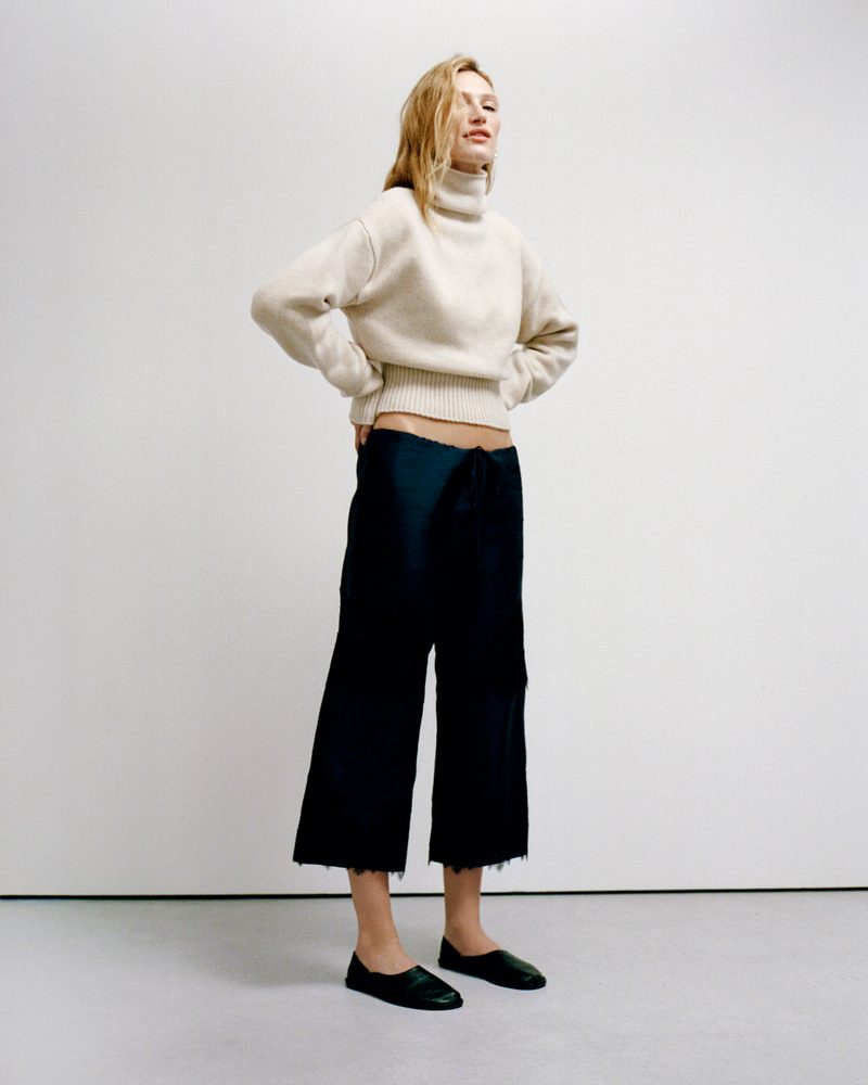 Cozy beige turtleneck sweater paired with black wide-leg cropped pants%2C completed with stylish black loafers for a chic autumn look