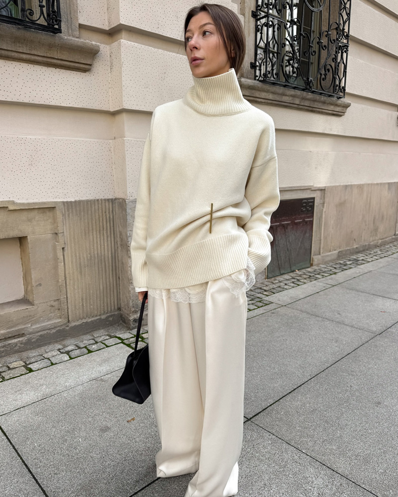 Street style look featuring a cream turtleneck sweater%2C satin wide-leg pants%2C and black tote%2C styled on a city sidewalk