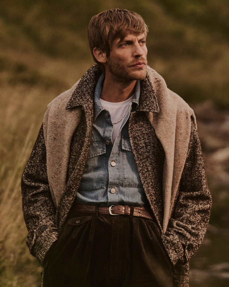 Rustic fall outfit featuring a textured wool overcoat layered over a denim jacket and corduroy trousers%2C styled outdoors in natural light