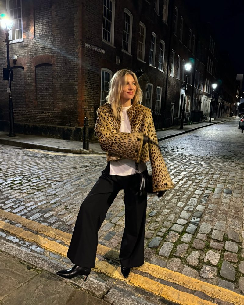 Leopard-print oversized coat layered over a white top and tailored black wide-leg trousers%2C styled with pointed black ankle boots for a chic evening look
