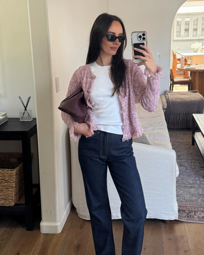 Mirror selfie outfit with pink textured cardigan%2C white tee%2C dark straight-leg jeans%2C sunglasses and clutch in cozy living room setting